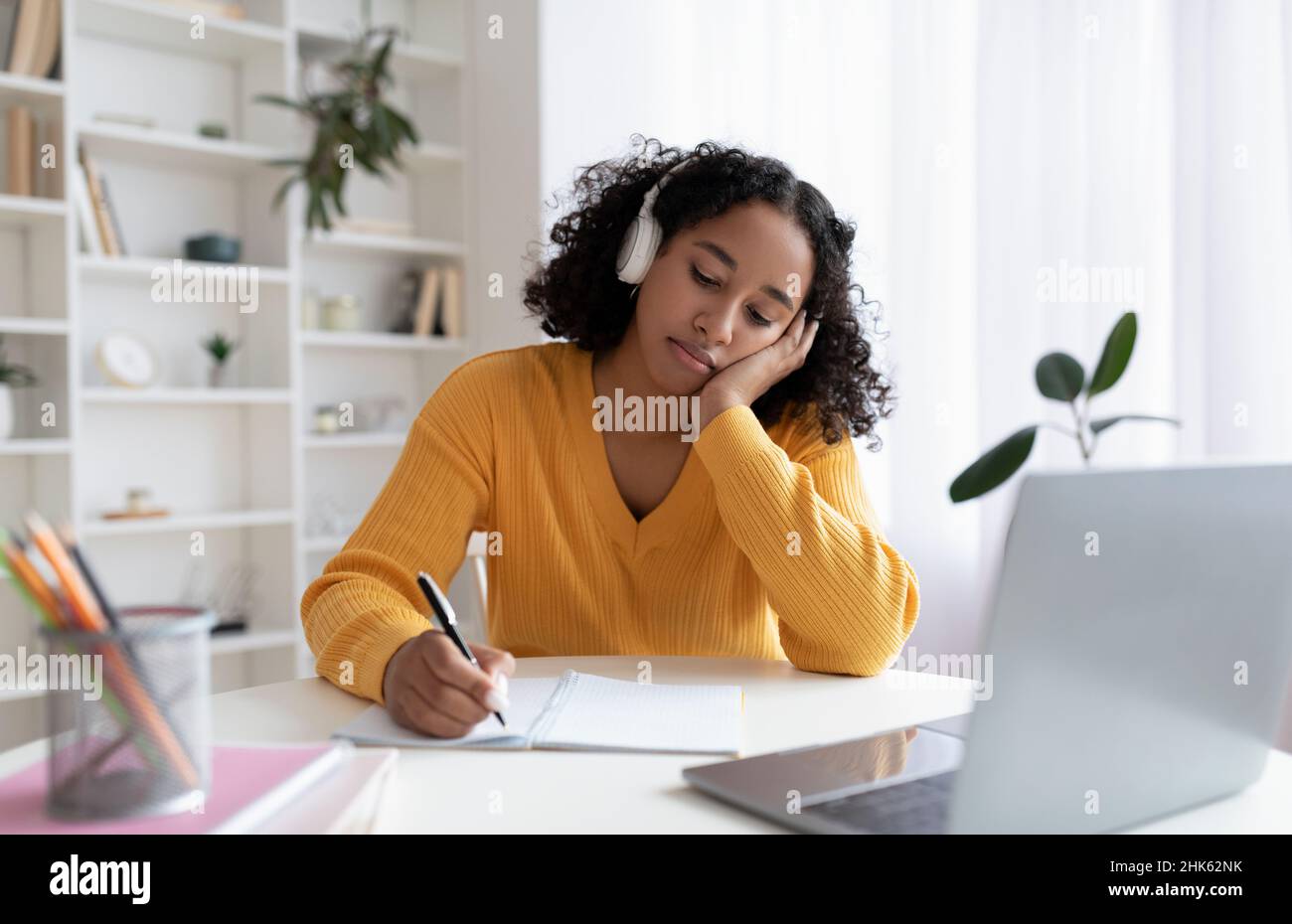 Bored young black female student having dull online lesson on laptop ...