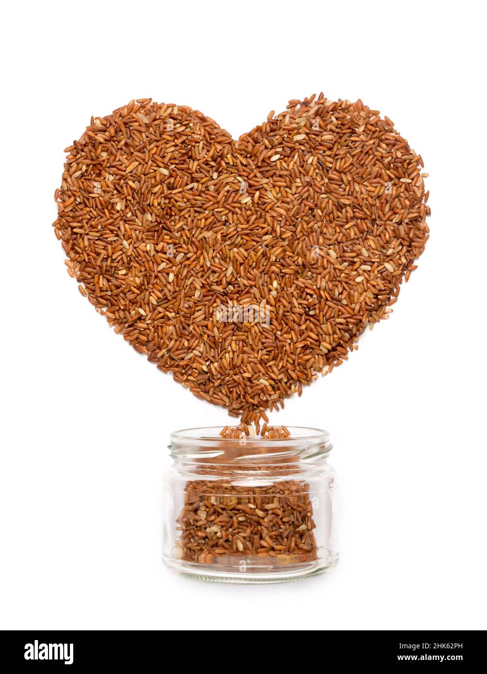 whole grain dark brown rice arranged in heart shape with a bottle on ...