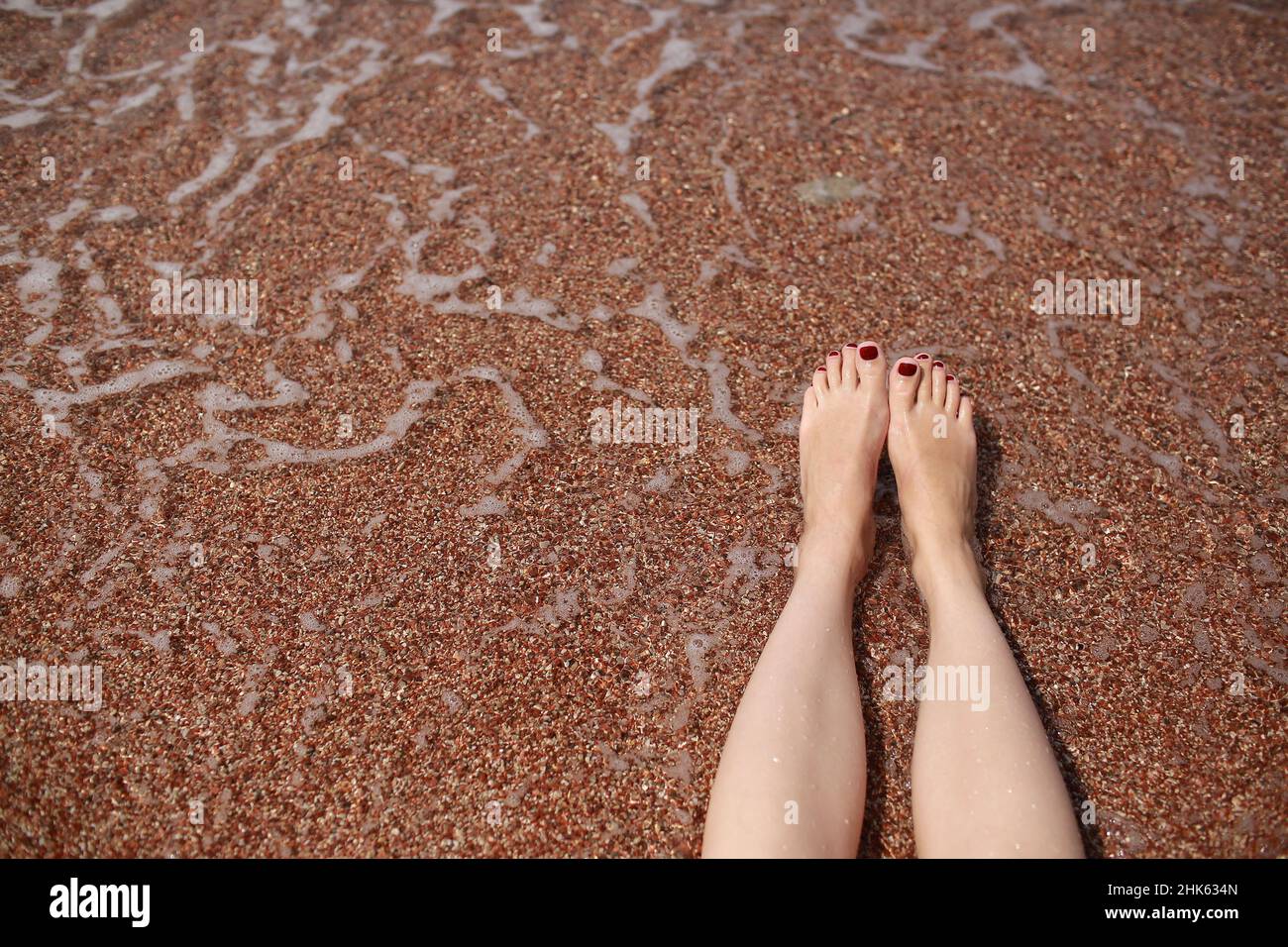Travel Concept Womans Legs On Beautiful Tropical Beach With Pebble