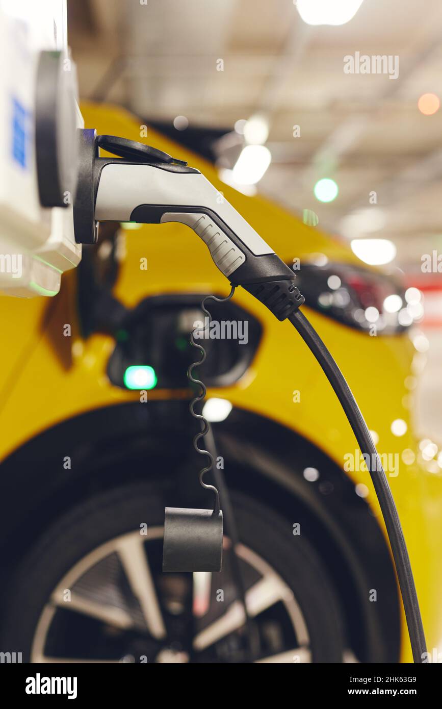 Electric car charging in underground car park in mall Stock Photo - Alamy