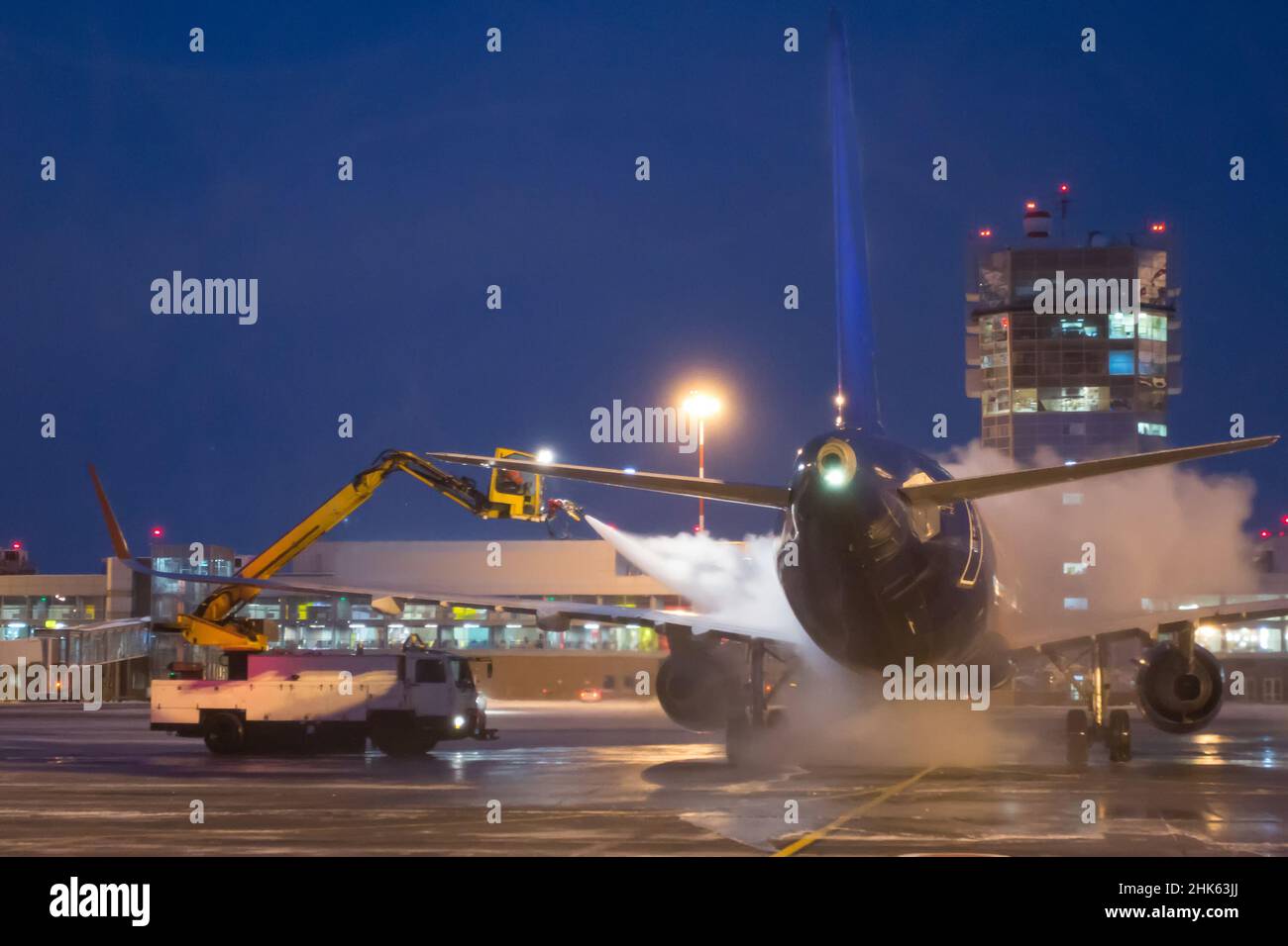 Ground deicing of a passenger airplane on the night airport apron Stock ...