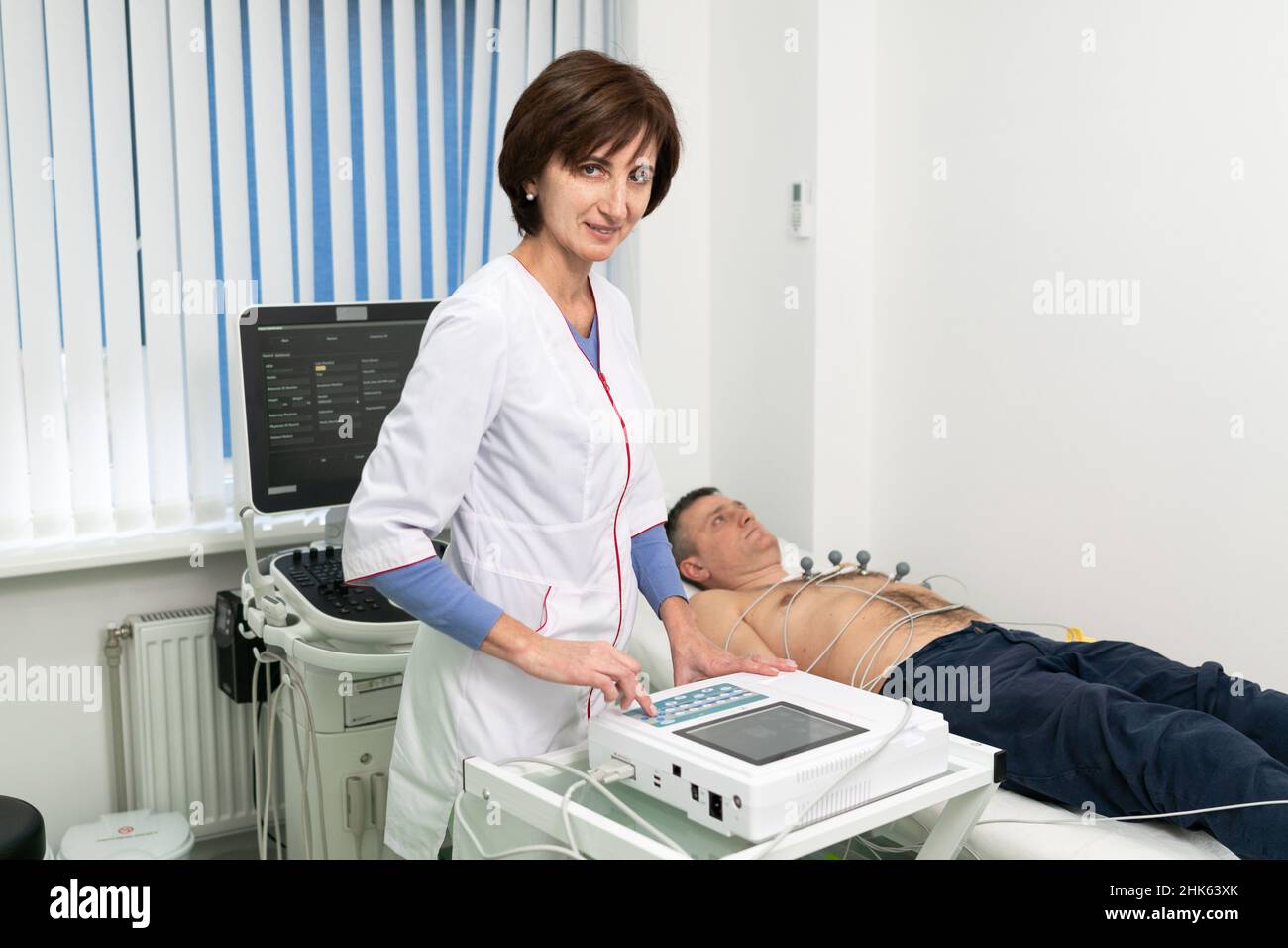 ECG concept. Woman doctor cardiologist doing electrocardiogram test to ...