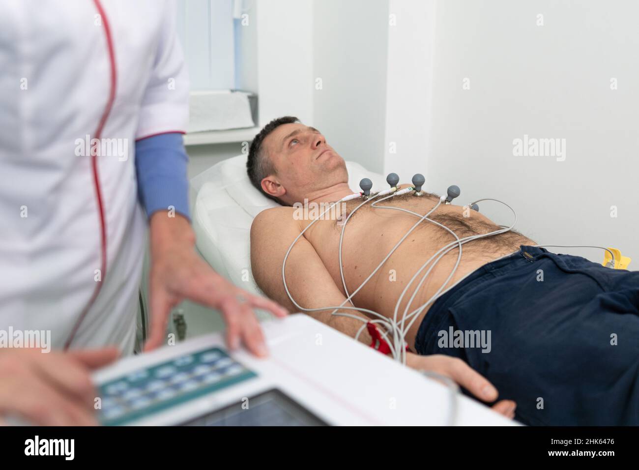 Medical equipment for electrocardiogram. Doctors doing ECG test on male ...