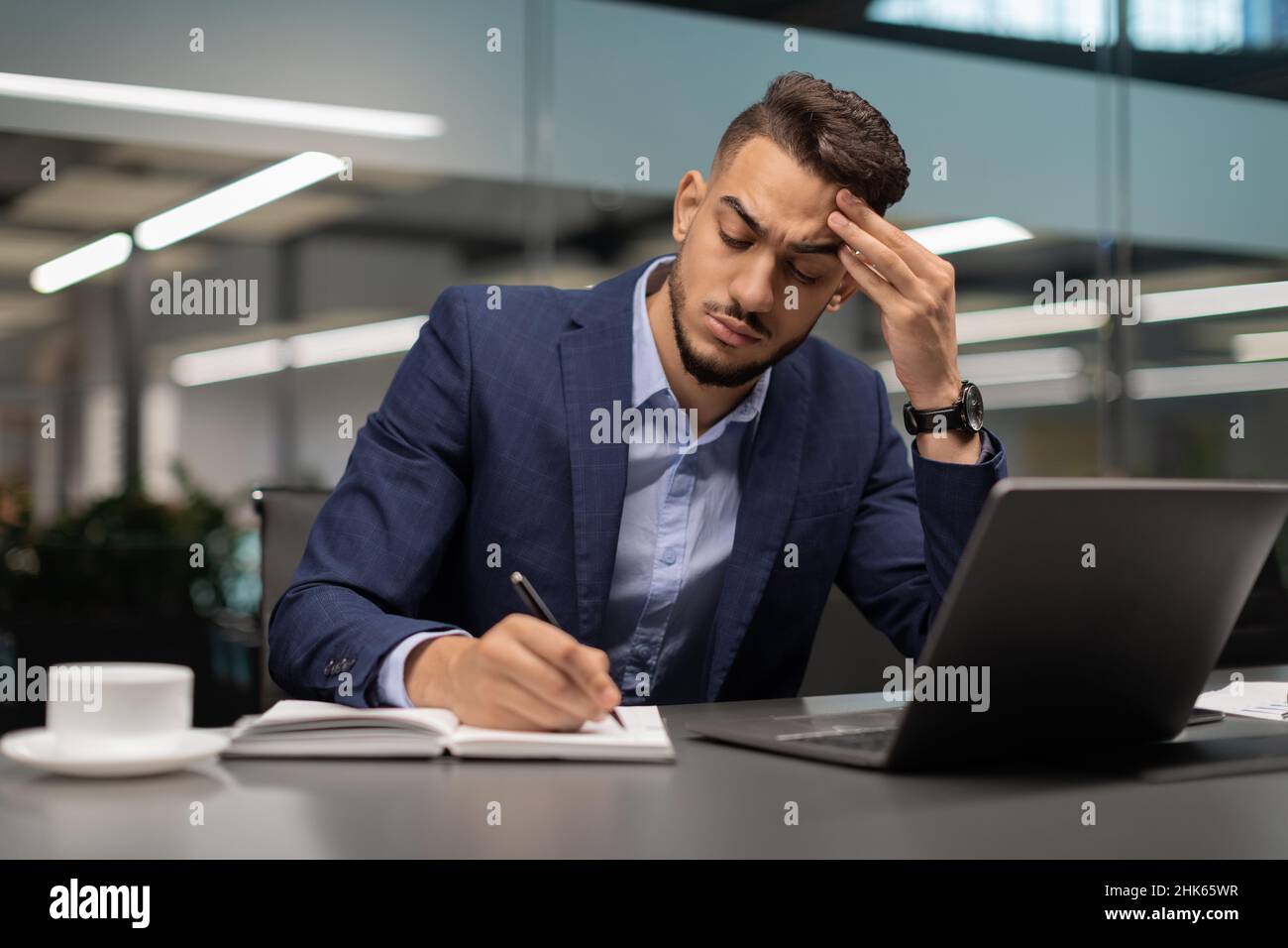 Concentrated arab man CEO taking notes at office Stock Photo - Alamy