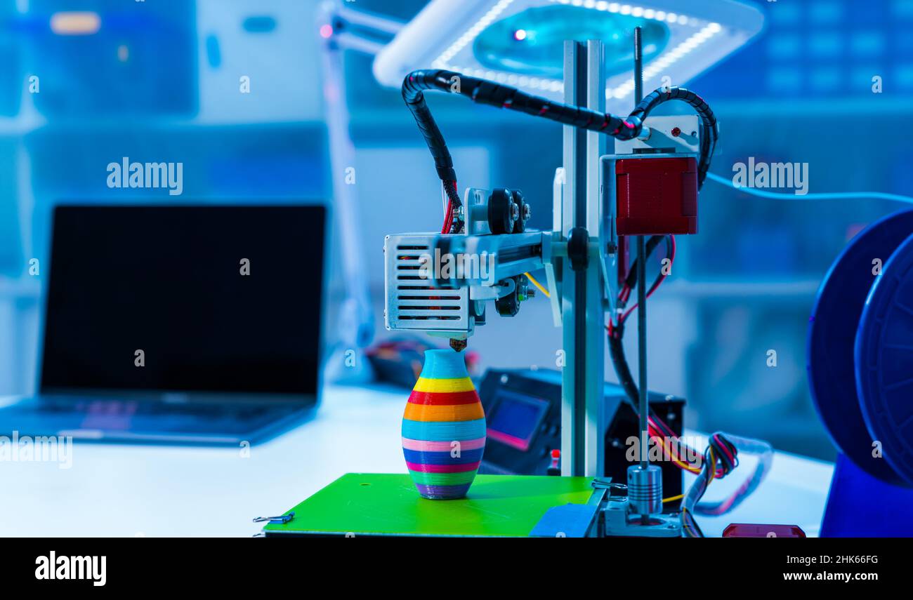 3D printer with a printed model on a computer table in a laboratory ...