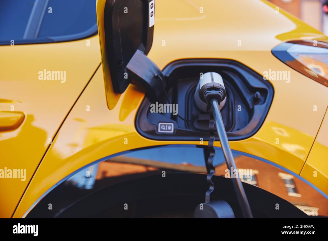 Electric car plugged in outside house on street Stock Photo - Alamy
