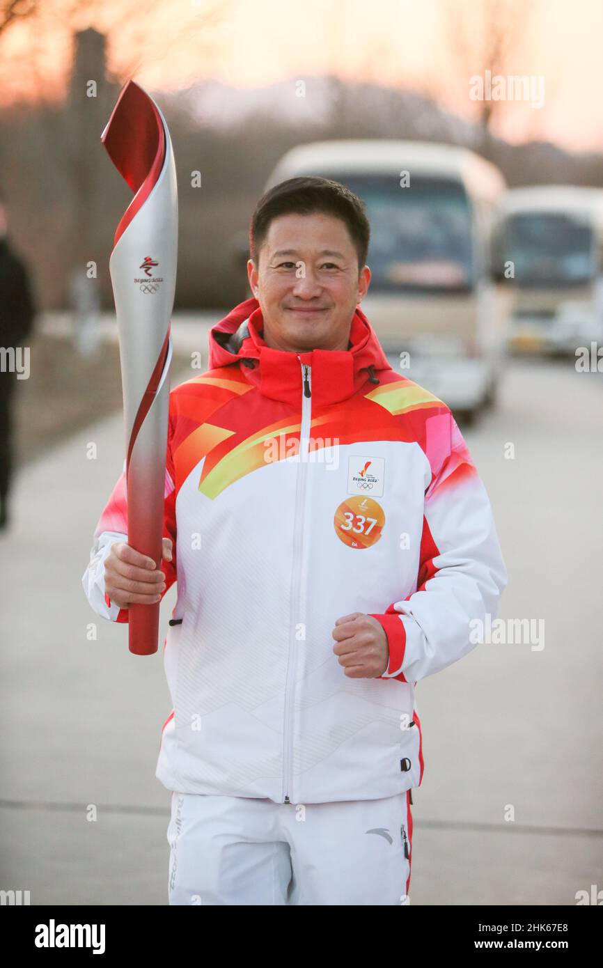Beijing, China. 2nd Feb, 2022. Torch bearer Wu Jing runs with the torch during the Beijing 2022 ...