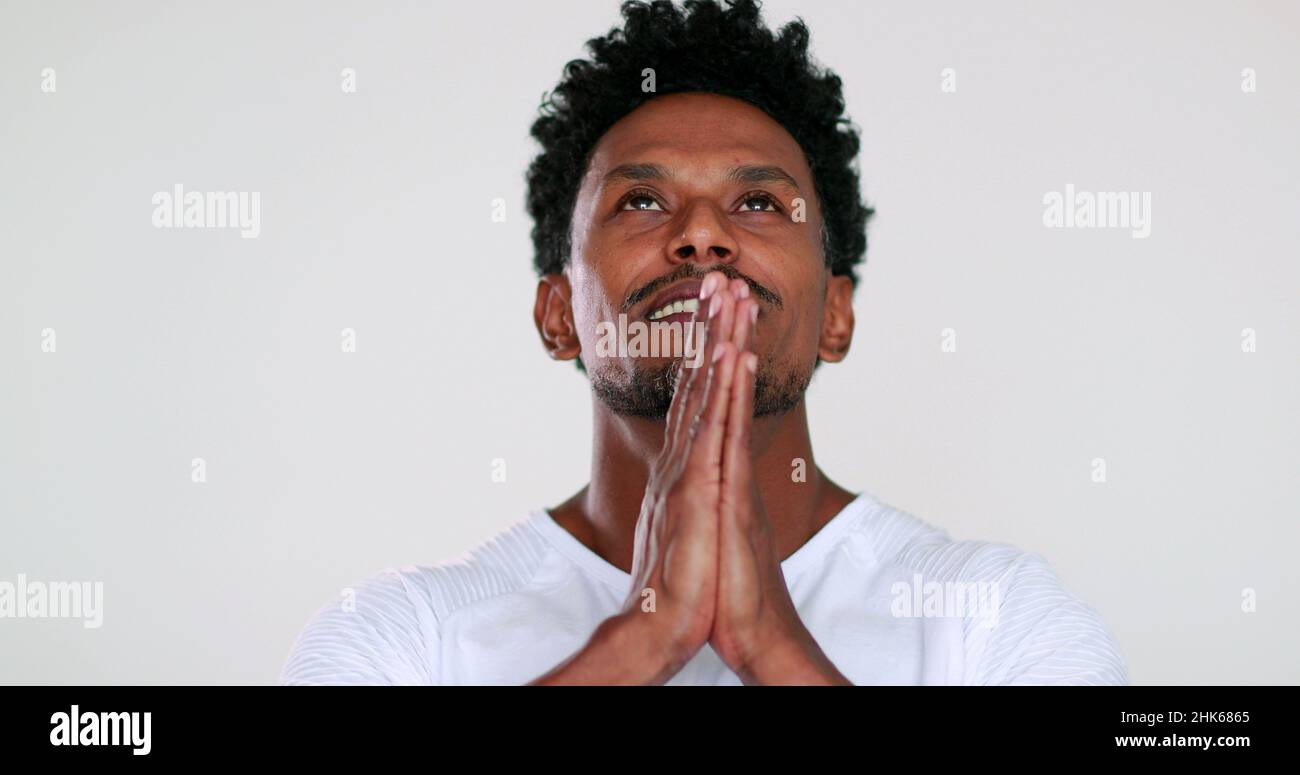 Black African man praying looking up to the sky with hope and faith ...