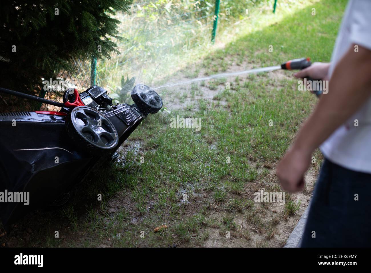 A lawn mower while being washed with a strong stream of water Stock ...