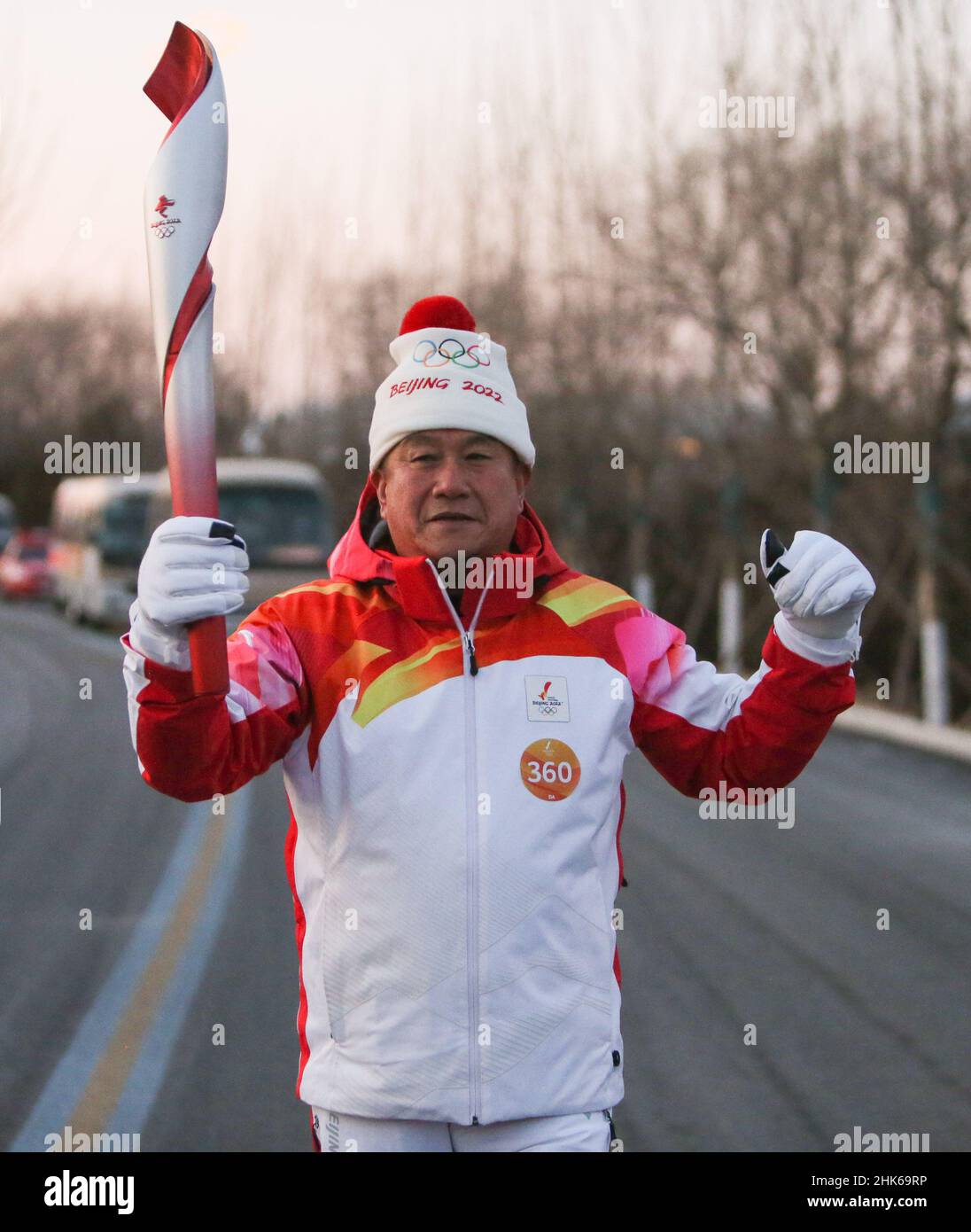 Beijing, China. 2nd Feb, 2022. Torch bearer Zhang Jingang runs with the torch during the Beijing ...