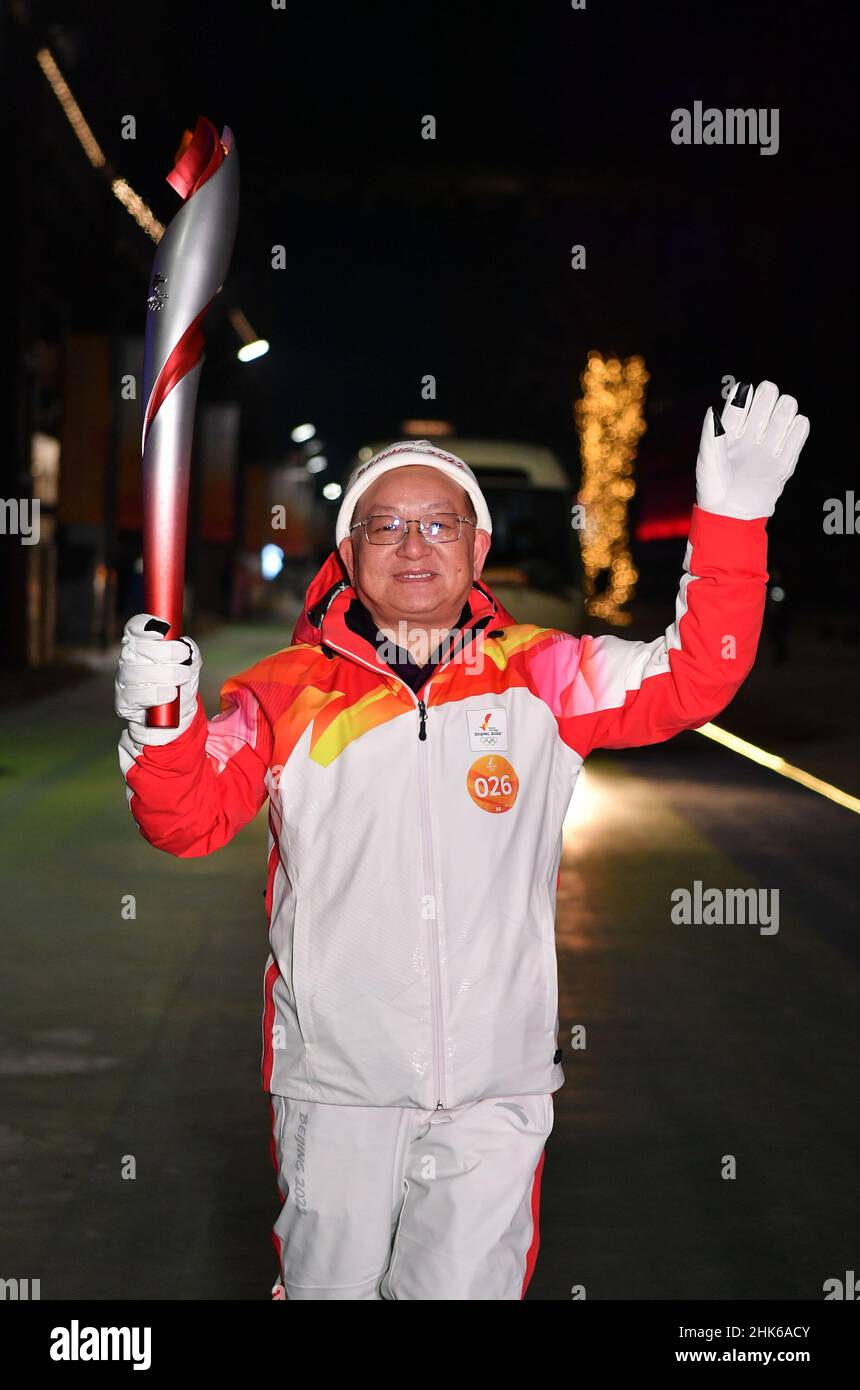 Beijing, China. 2nd Feb, 2022. Torch bearer Zhou Zhiliang runs with the ...