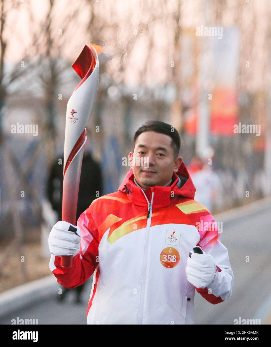 Beijing, China. 2nd Feb, 2022. Torch bearer Zhang Hailong runs with the torch during the Beijing ...