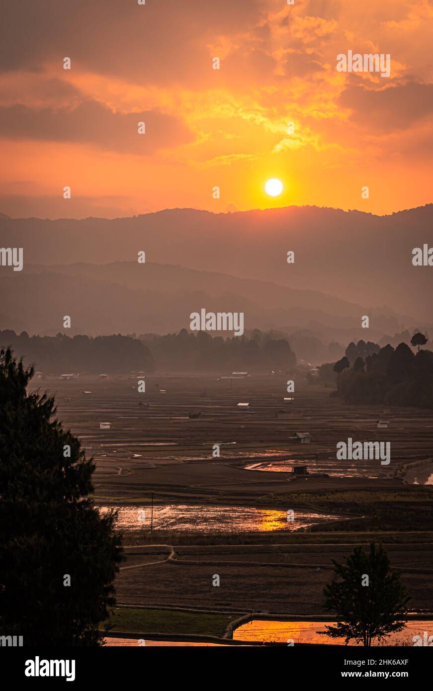 sunrise over mountains with country side farming fields and orange ...