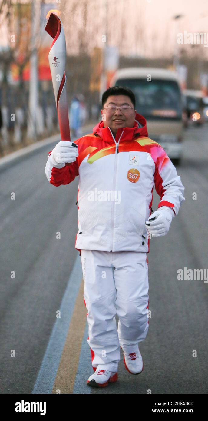 Beijing, China. 2nd Feb, 2022. Torch bearer Zhang Chi runs with the torch during the Beijing ...