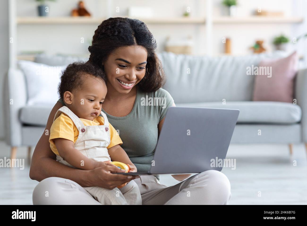 Modern Technologies. Young Black Woman With Infant Baby Using Laptop At ...