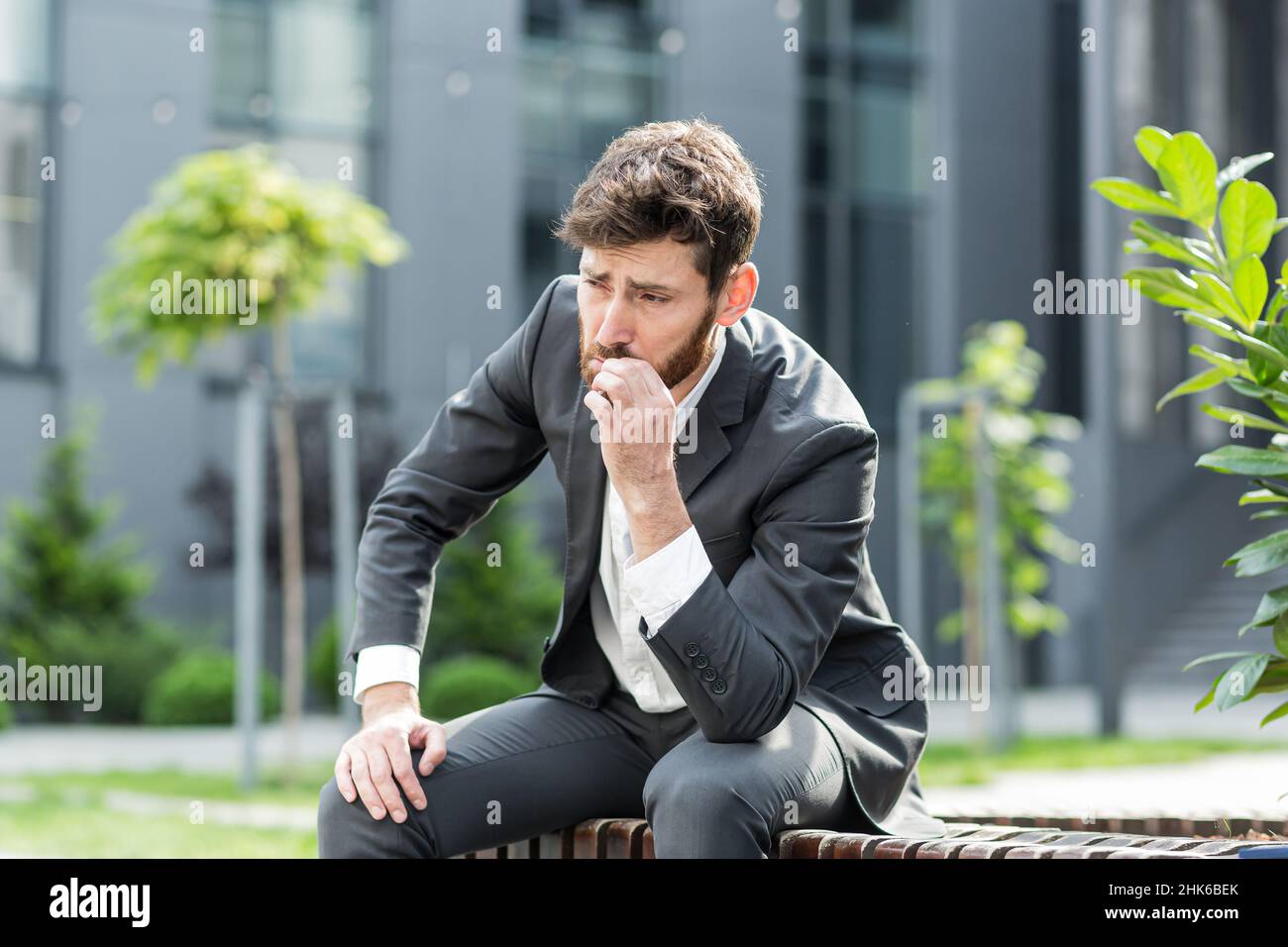 Male businessman smoking cigarette in the air near the office relieves ...