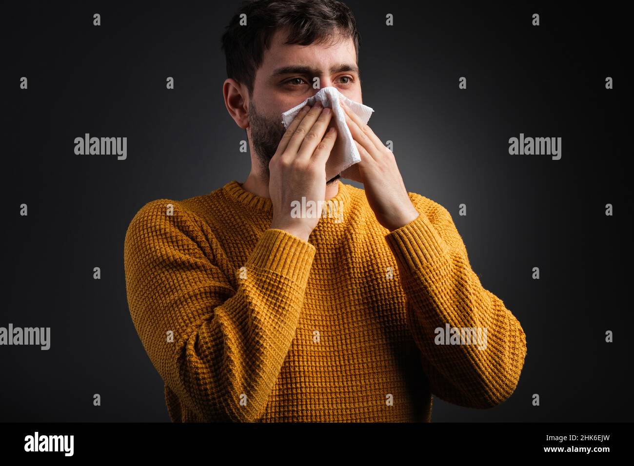 Close up photo of a man covering his nose with a handkerchief feeling ...