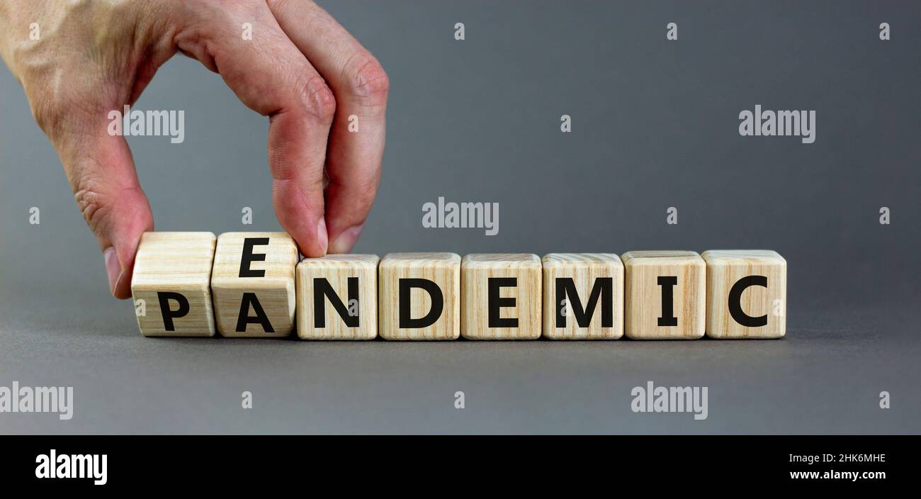 Covid-19 pandemic or endemic symbol. Doctor turns wooden cubes and ...