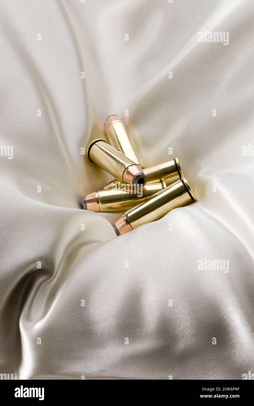 Group of bullets laying on satin pillow Stock Photo - Alamy