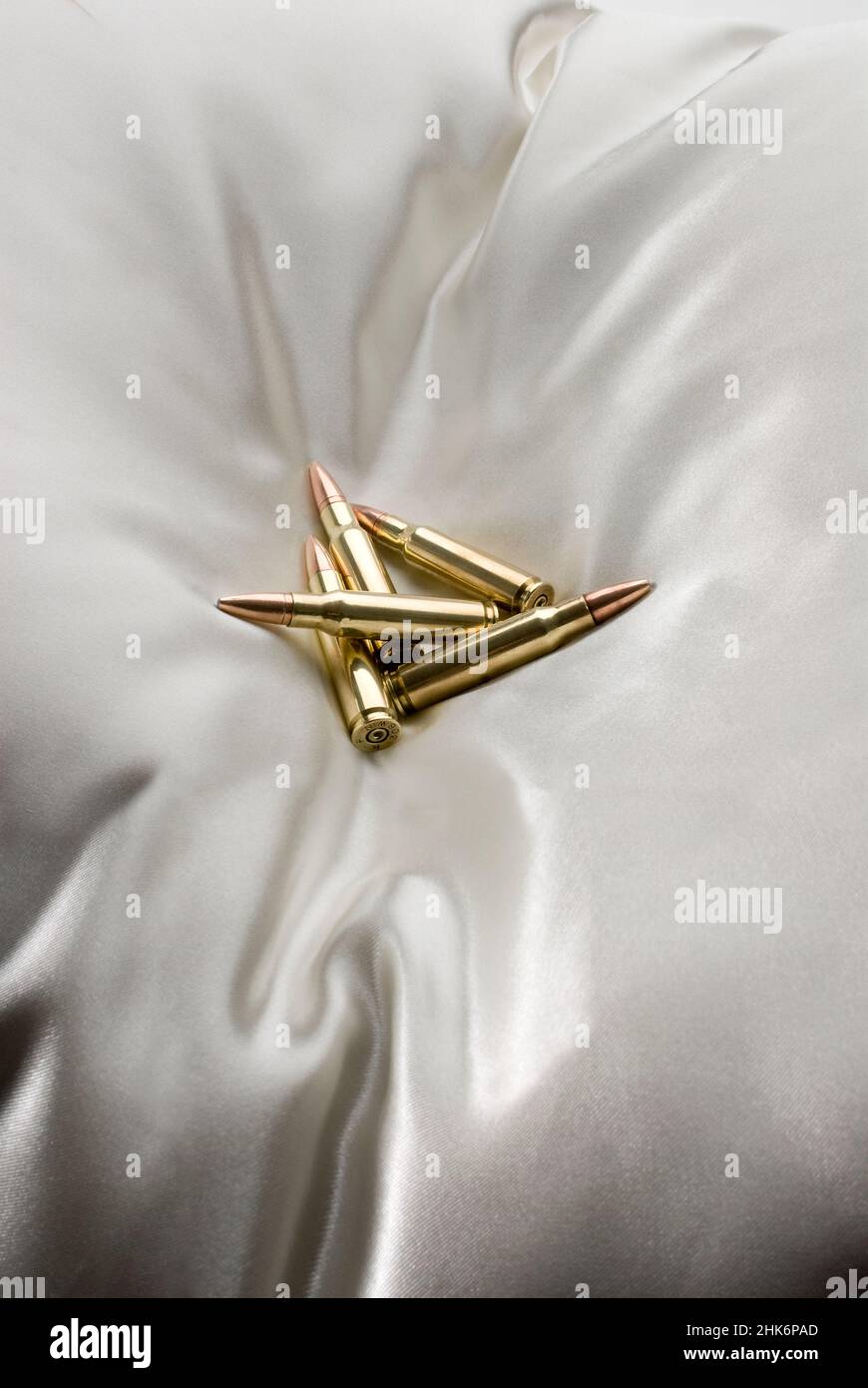 Group of bullets laying on satin pillow Stock Photo - Alamy