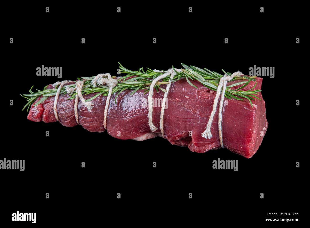 An uncut piece of fresh raw beef tenderloin on a marble table with ...