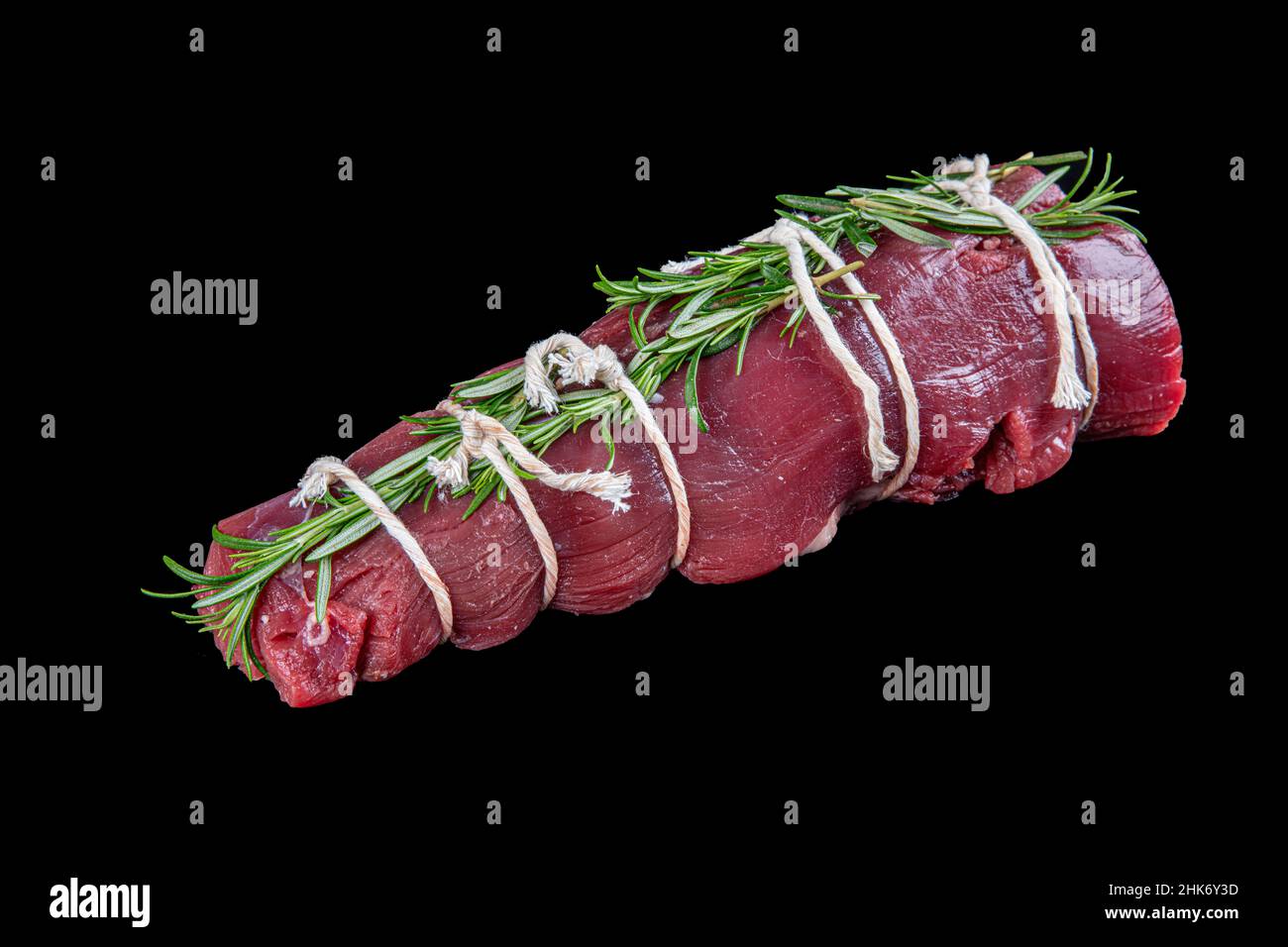 An uncut piece of fresh raw beef tenderloin on a marble table with ...