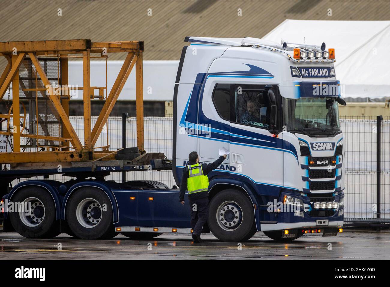 UK Border Force officer handing back paperwork to a lorry driver at the ...