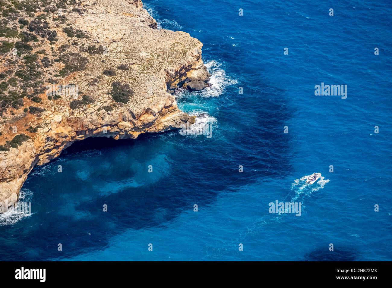 Aerial view, rocky coast and motorboat in front of Manacor, Balearic ...
