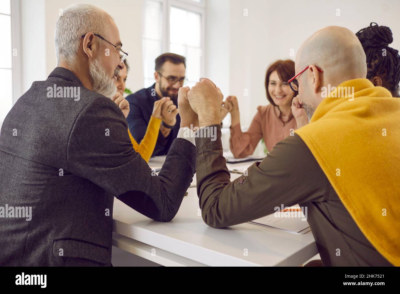 Team of happy business colleagues sitting together around table ...