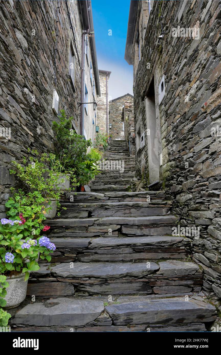 Narrow cobbled street and schist houses in the medieval mountain ...