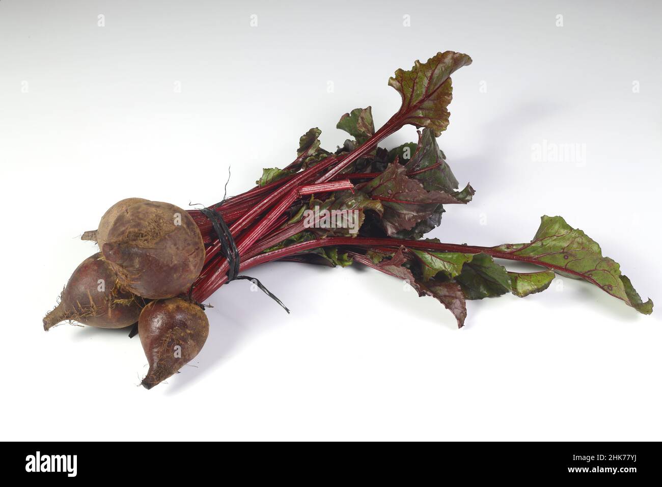 bundle of fresh organic garden beet roots with greens isolated on white ...