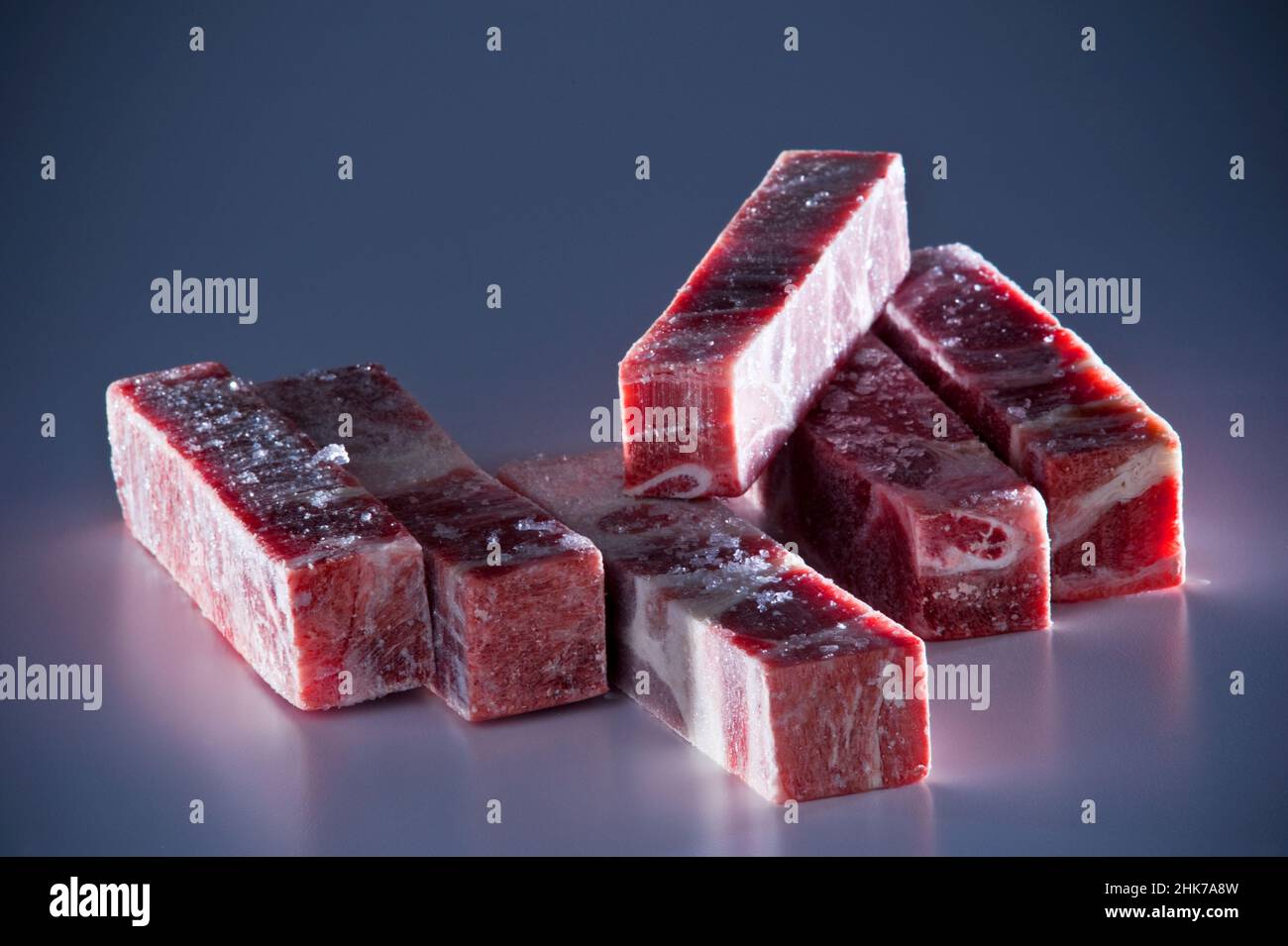 Rectangular cuts of frozen beef laying on dark background Stock Photo ...