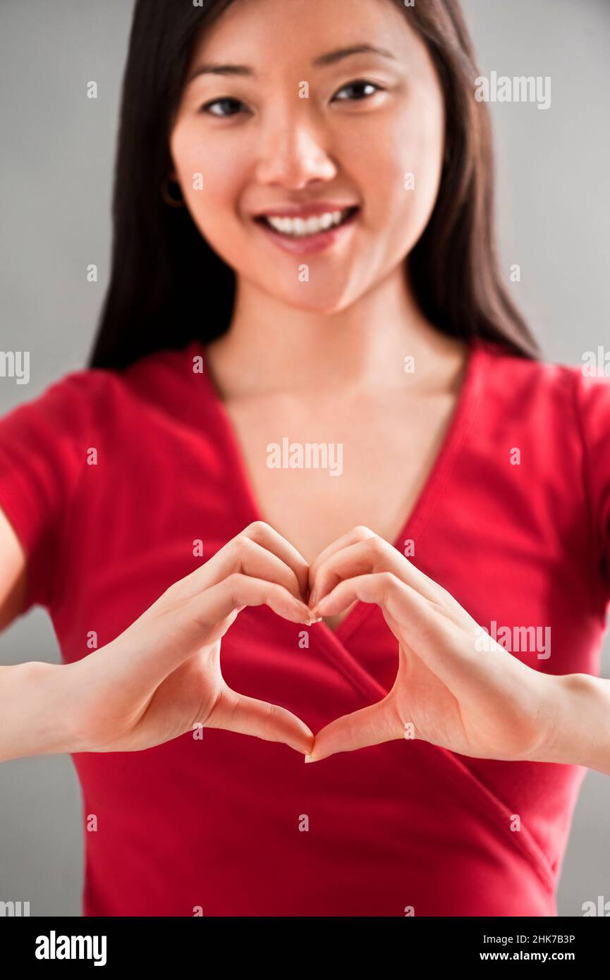 Asian woman making heart sign Stock Photo - Alamy