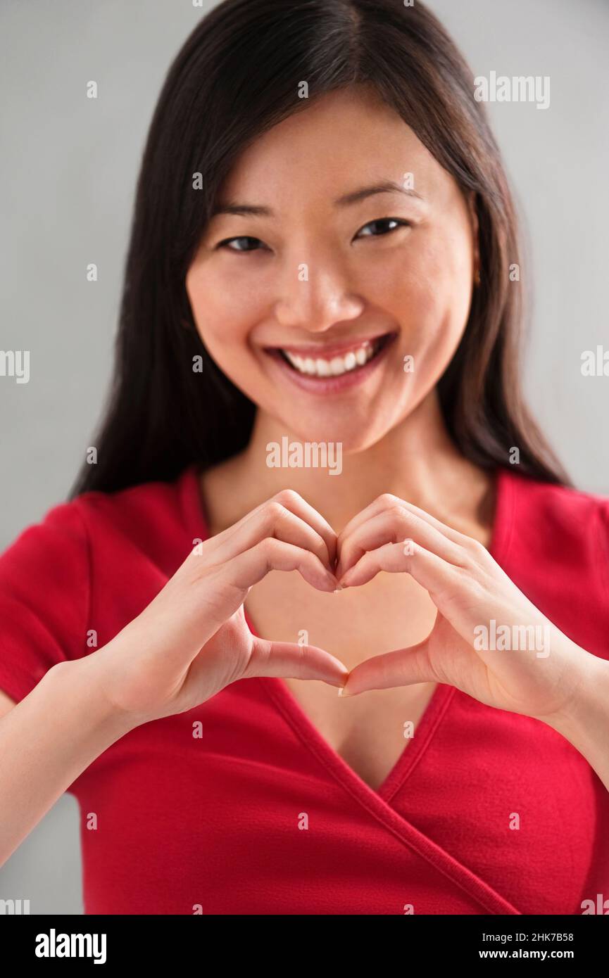 Asian woman making heart sign Stock Photo - Alamy