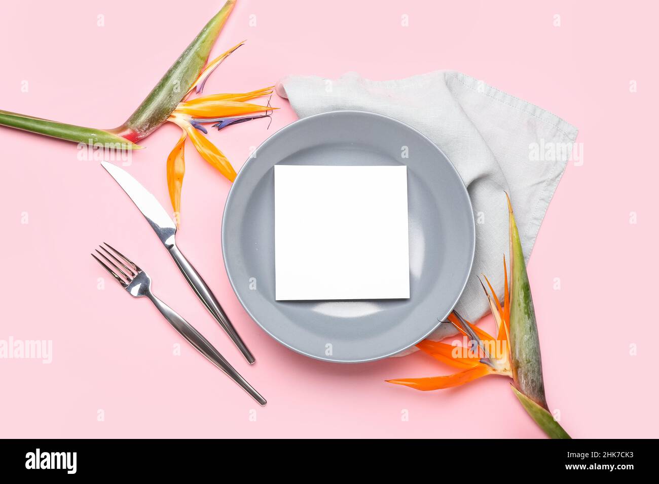 Simple table setting with bird of paradise flowers and blank card on ...