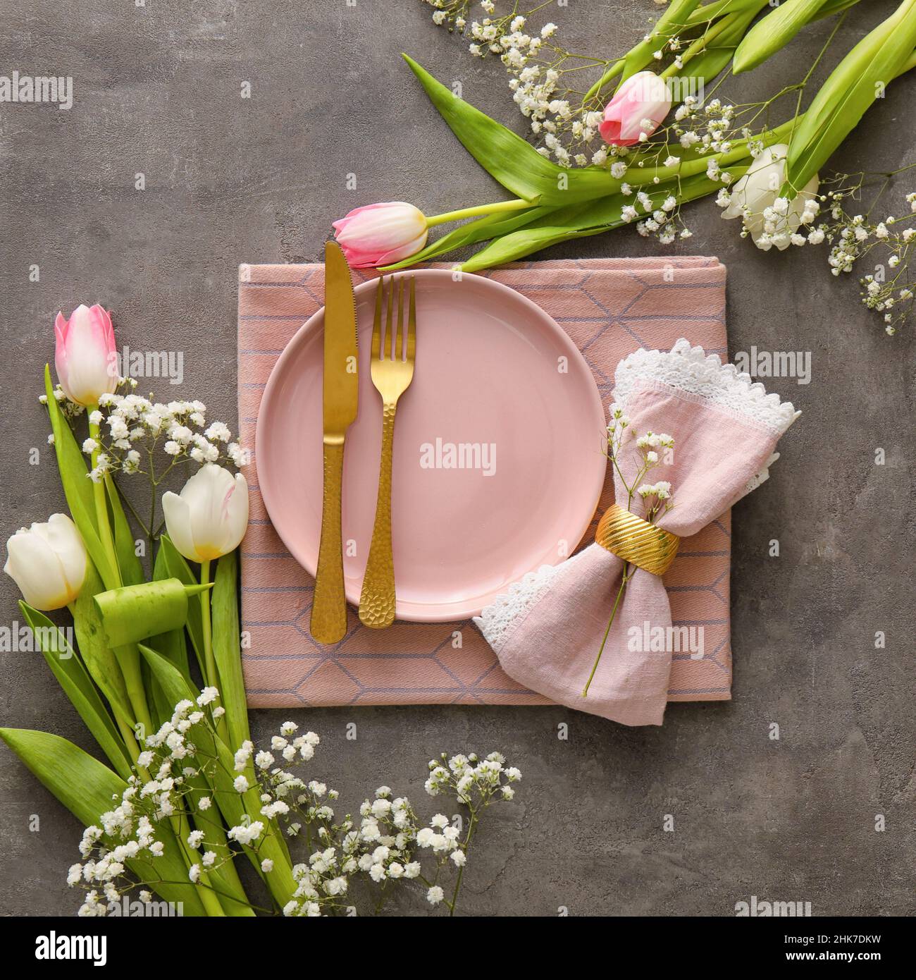 Spring table setting with beautiful flowers on grey grunge background ...