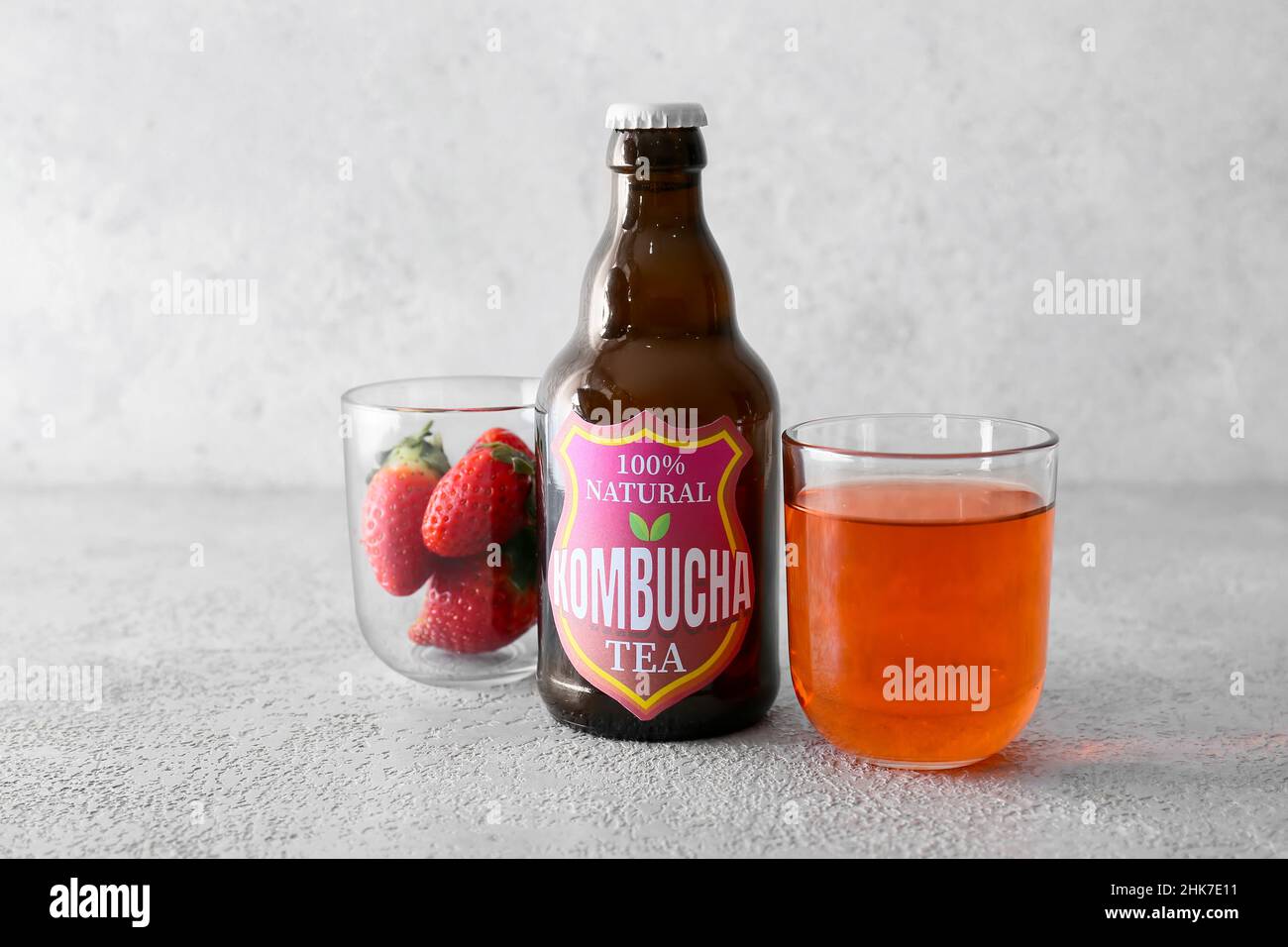 Bottle and glass of fresh strawberry kombucha on light background Stock ...