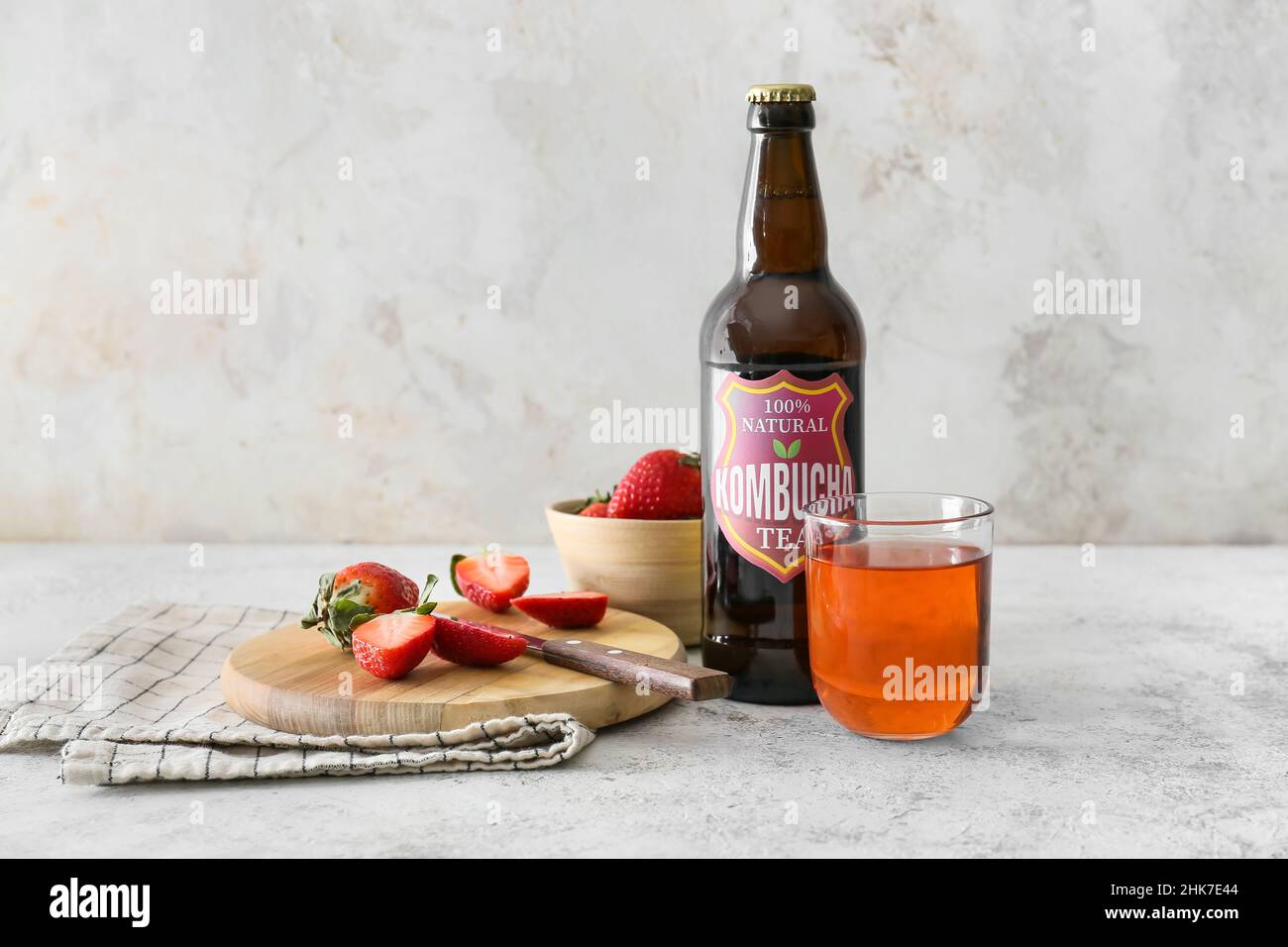 Bottle and glass of fresh strawberry kombucha on light background Stock ...