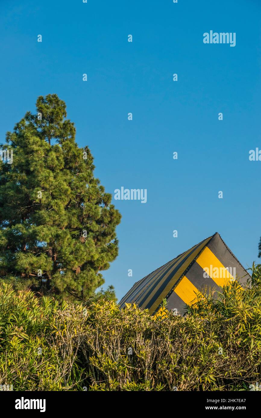 A tall A-frame roofed church that is tented for fumigation with a ...