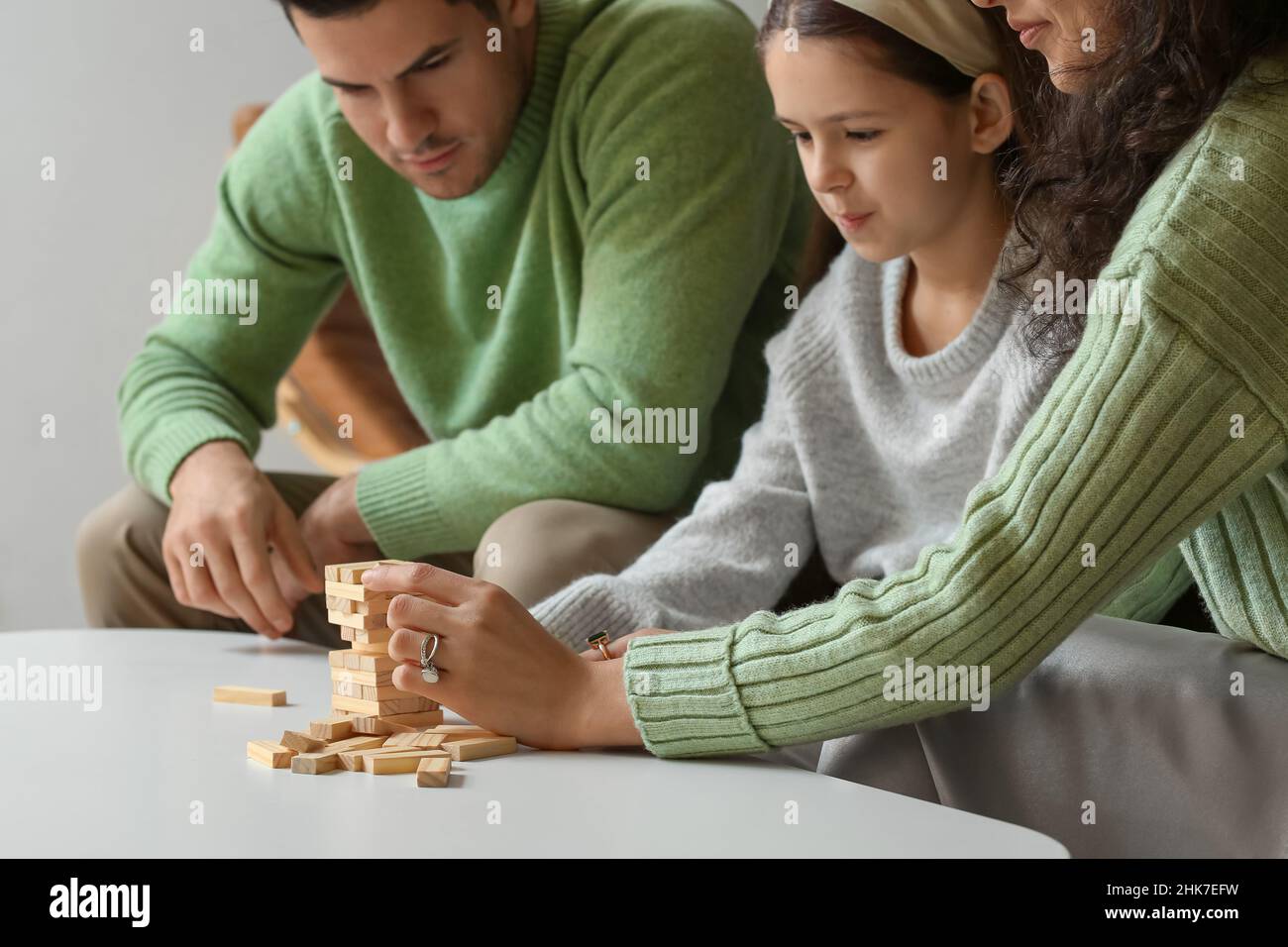 Happy family in warm sweaters playing jenga game at home, closeup Stock ...