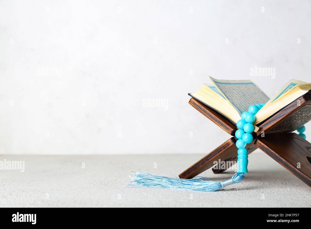 Rehal with Koran and Muslim prayer beads on light background Stock ...
