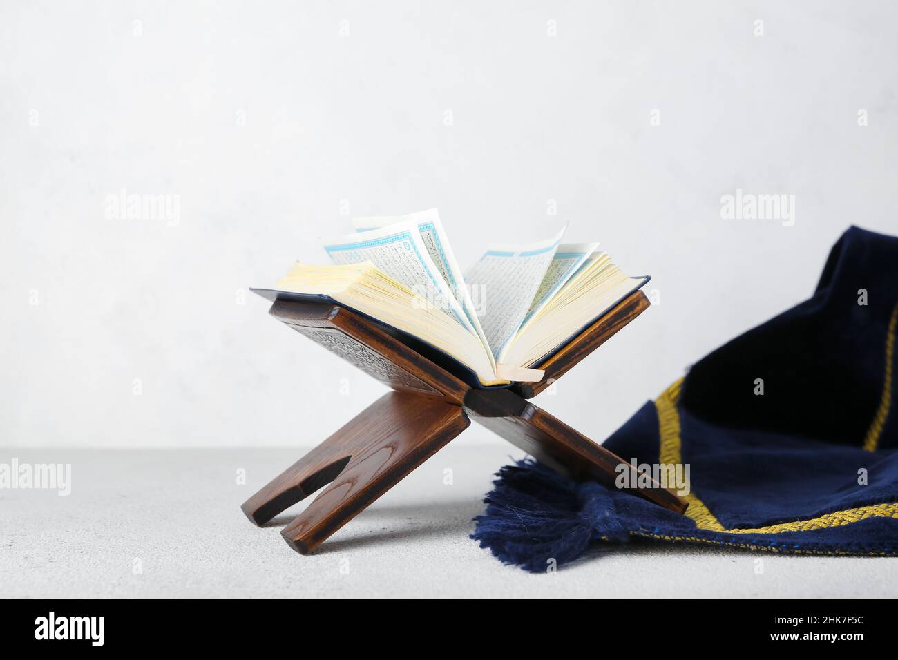 Rehal with Koran and Muslim prayer mat on light background Stock Photo ...