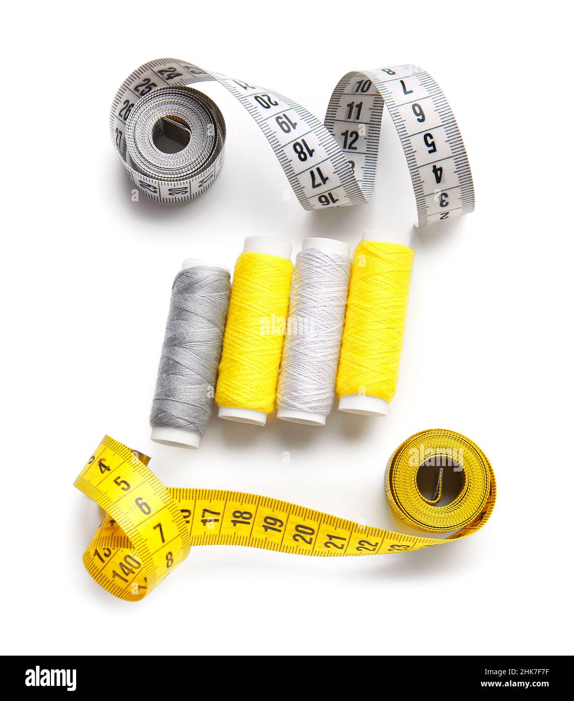 Thread spools with measuring tapes on white background Stock Photo - Alamy