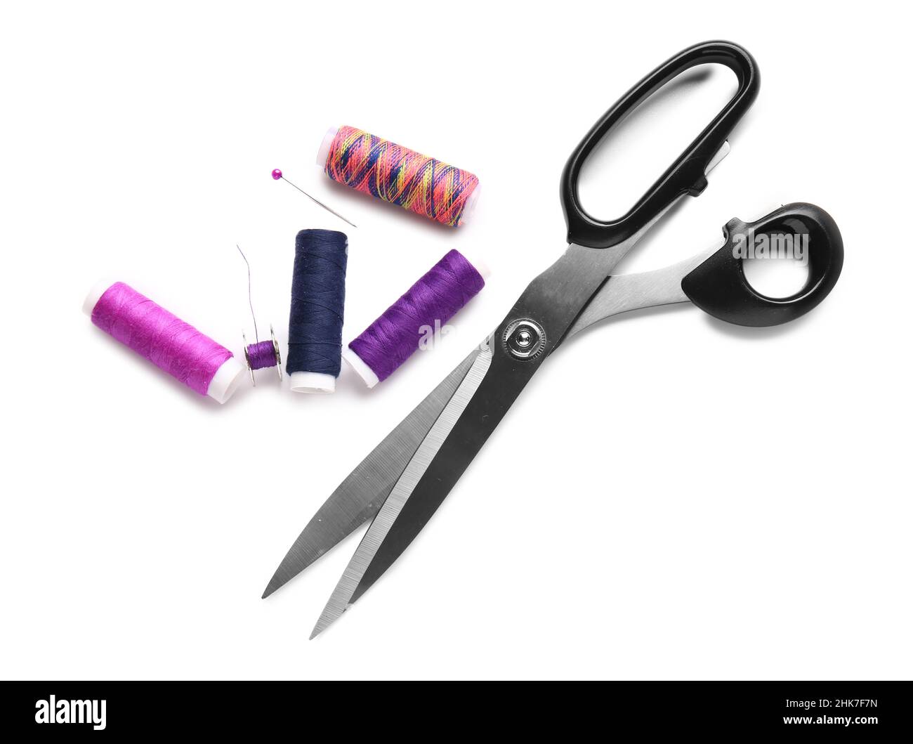 Thread spools with scissors on white background Stock Photo - Alamy