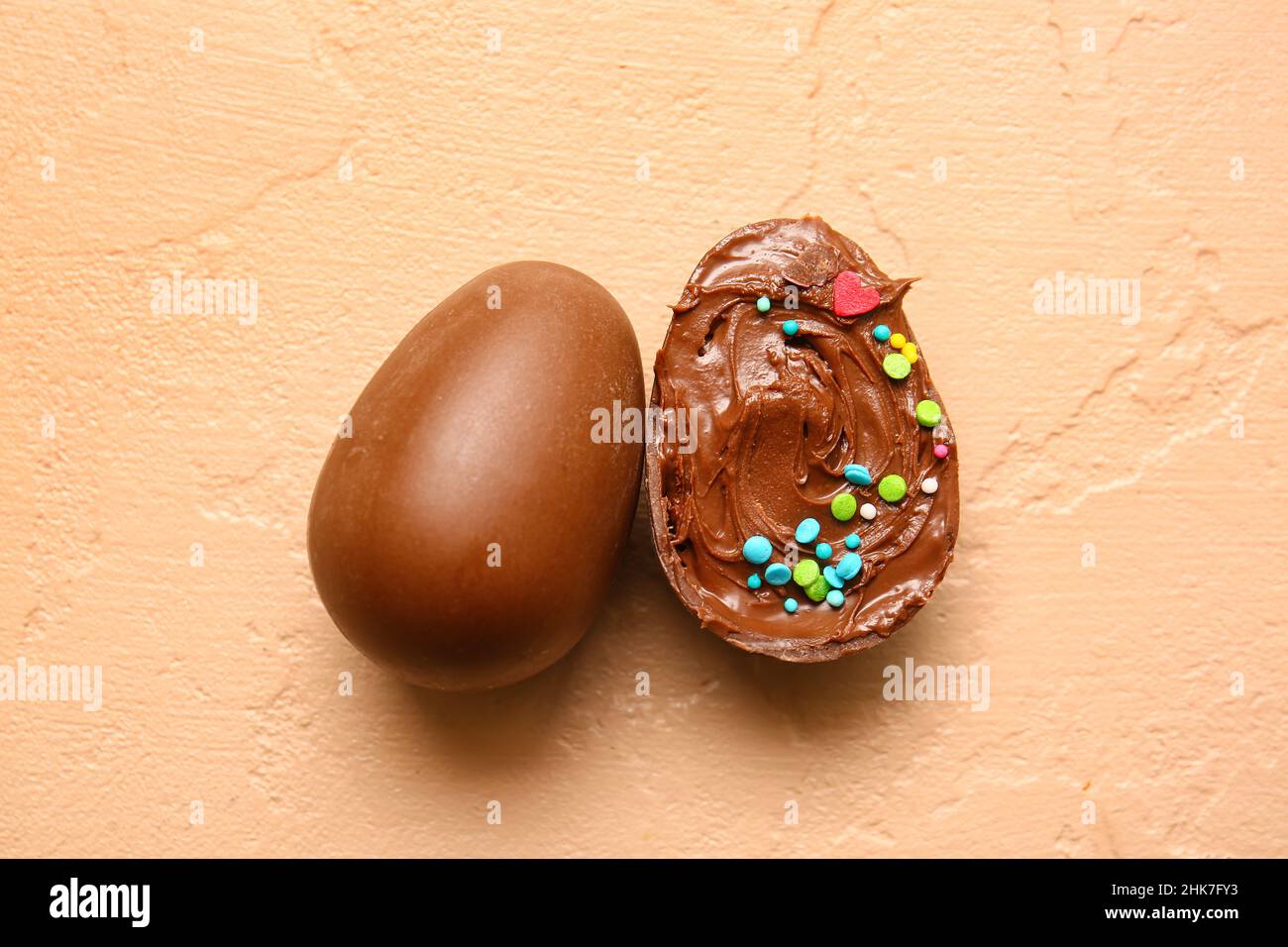 Easter egg with chocolate paste and sprinkles on beige background Stock Photo - Alamy