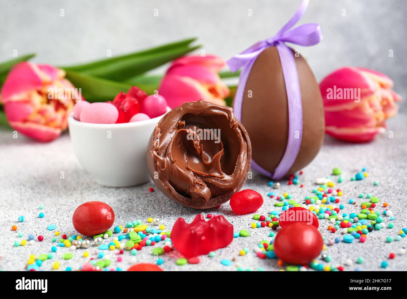 Easter eggs with chocolate paste and different candies on light background, closeup Stock Photo ...