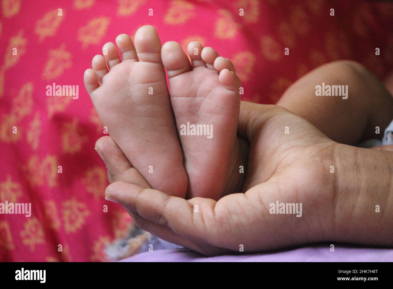 Father's hand holding small baby feet Stock Photo - Alamy