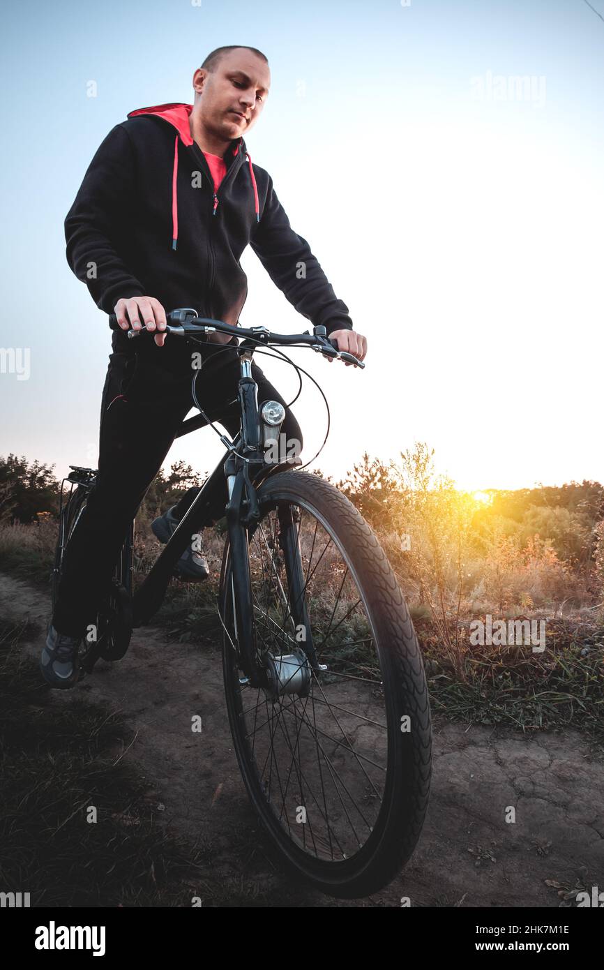Man on a bike in the autumn forest in the evening at sunset Stock Photo - Alamy