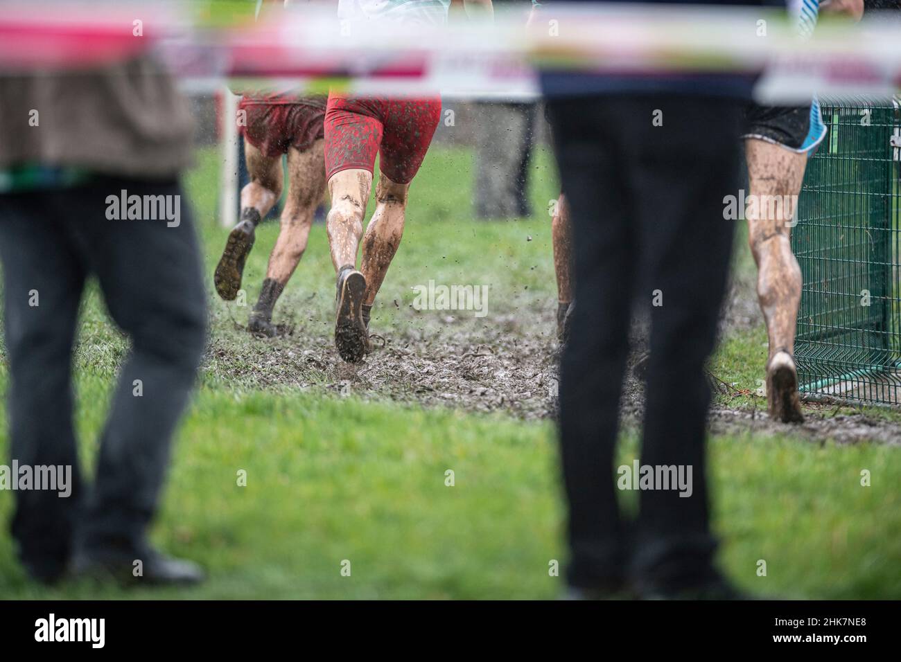 Athlete's legs running in a Cross Country between water and mud, pure ...