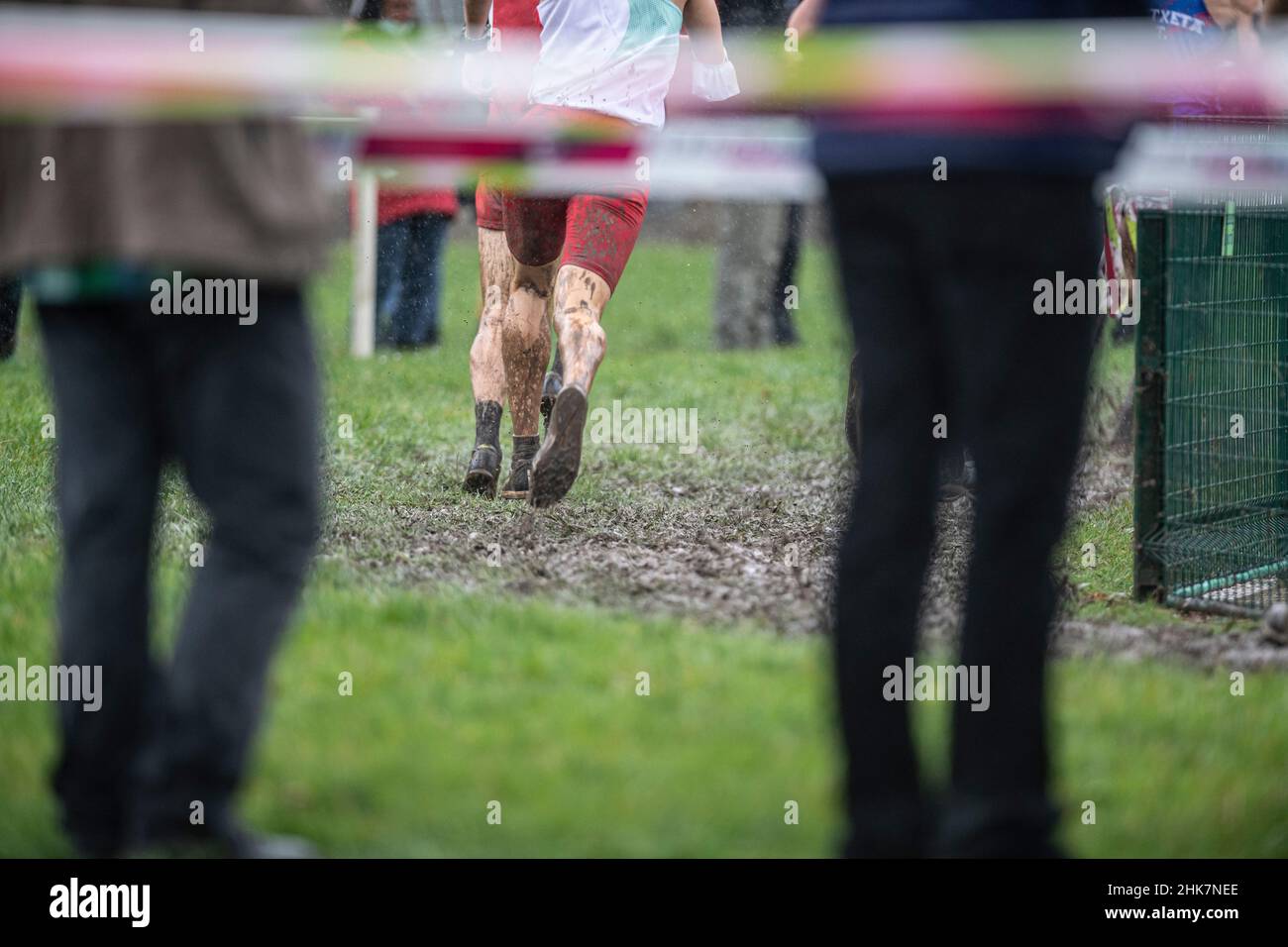 Athlete's legs running in a Cross Country between water and mud, pure ...
